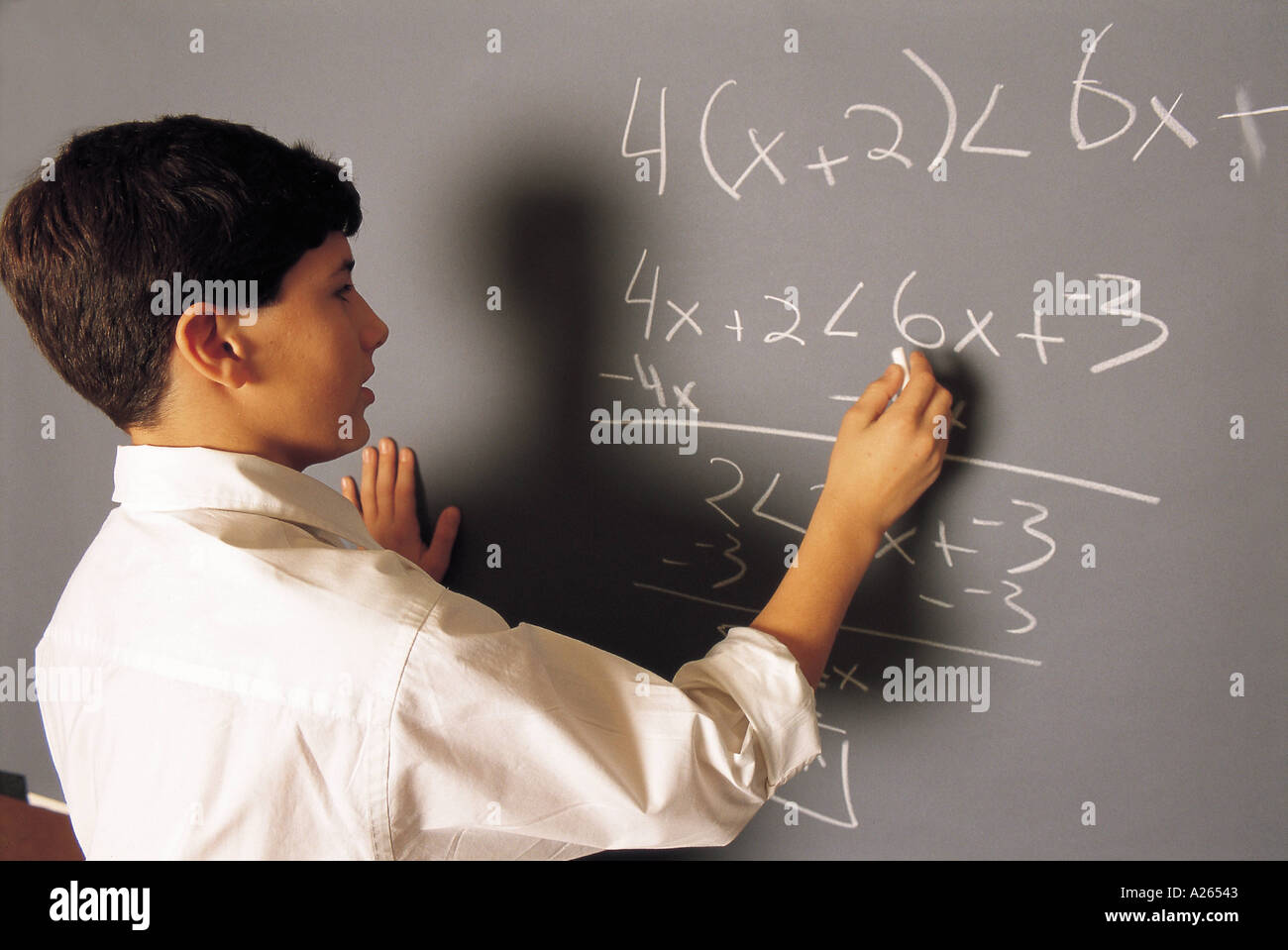 BOY WORKING OUT MATHS ON A CHALK BOARD Stock Photo - Alamy
