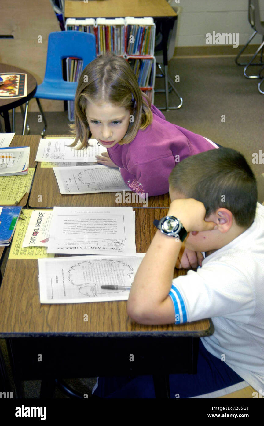 3rd grade elementary students working together in group helping each ...