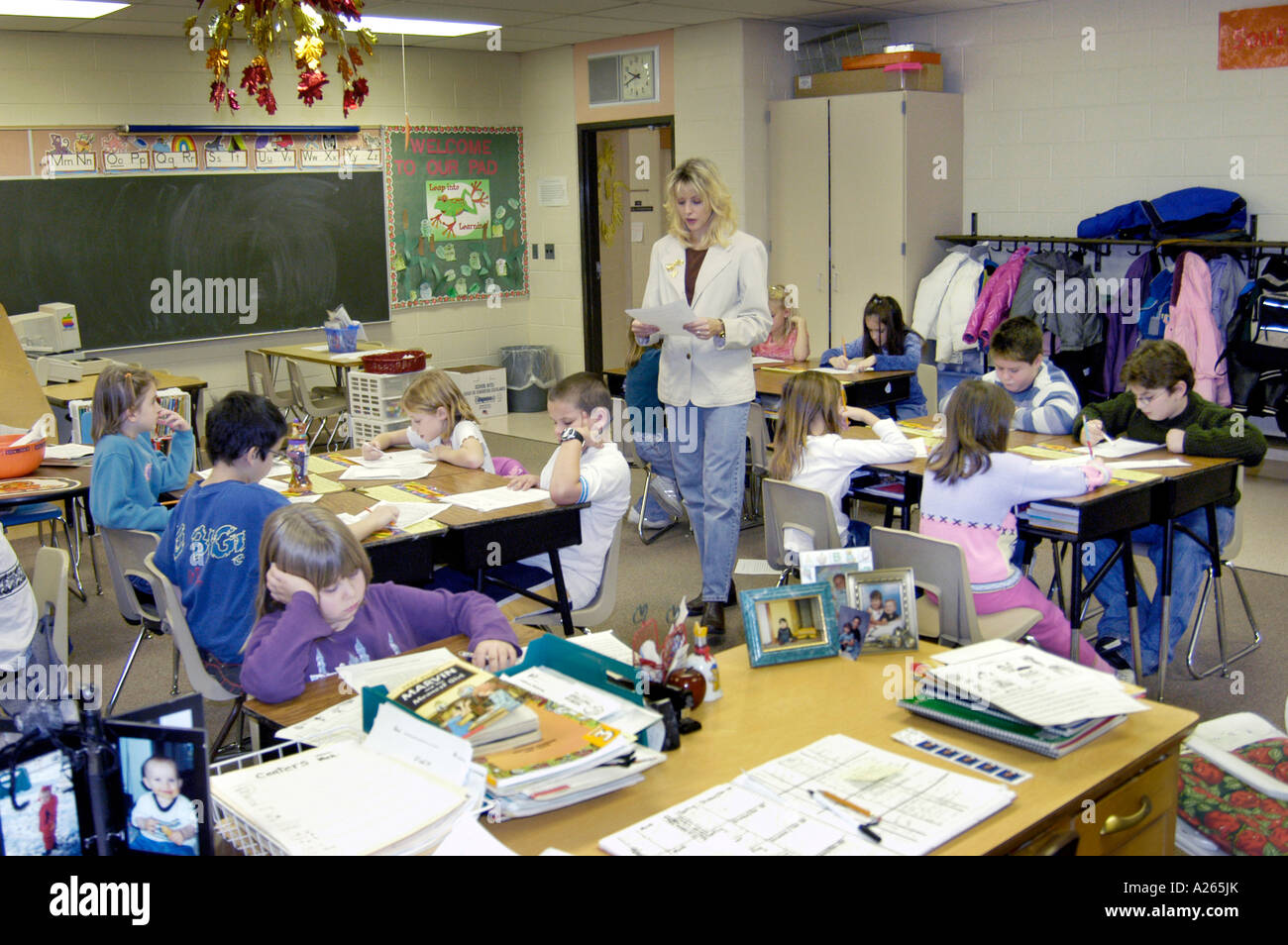 3rd grade elementary class with teacher teaching a group of students ...