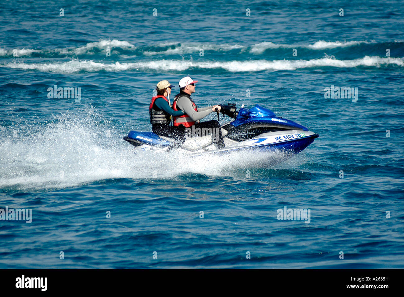 couple riding on a wave runner Stock Photo - Alamy