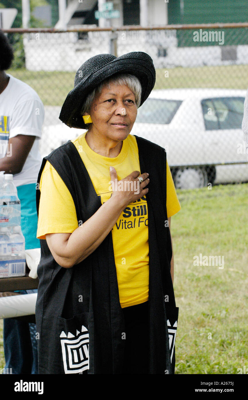 Black senior female holds hand over her heart while singing the ...