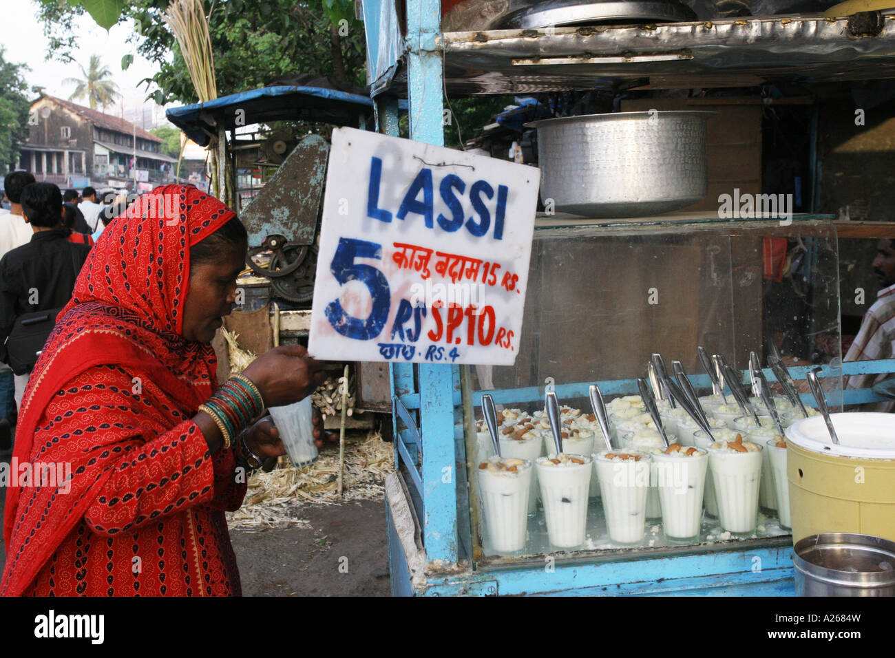 Lady buying a glass of lassi from a street stall in Bombay India Stock ...