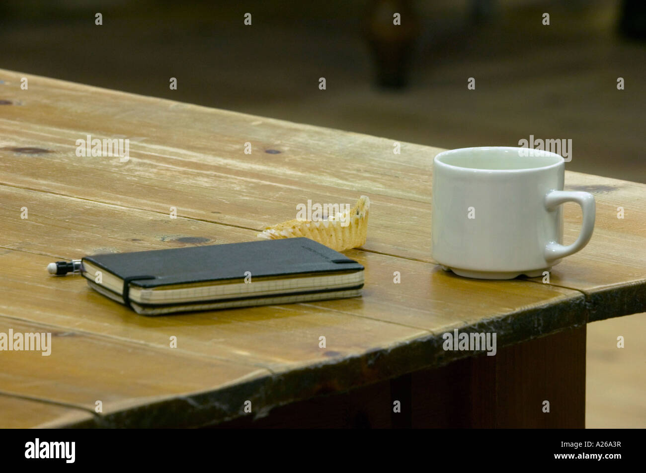 notepad pencil cup and cake wrapper on table Stock Photo - Alamy