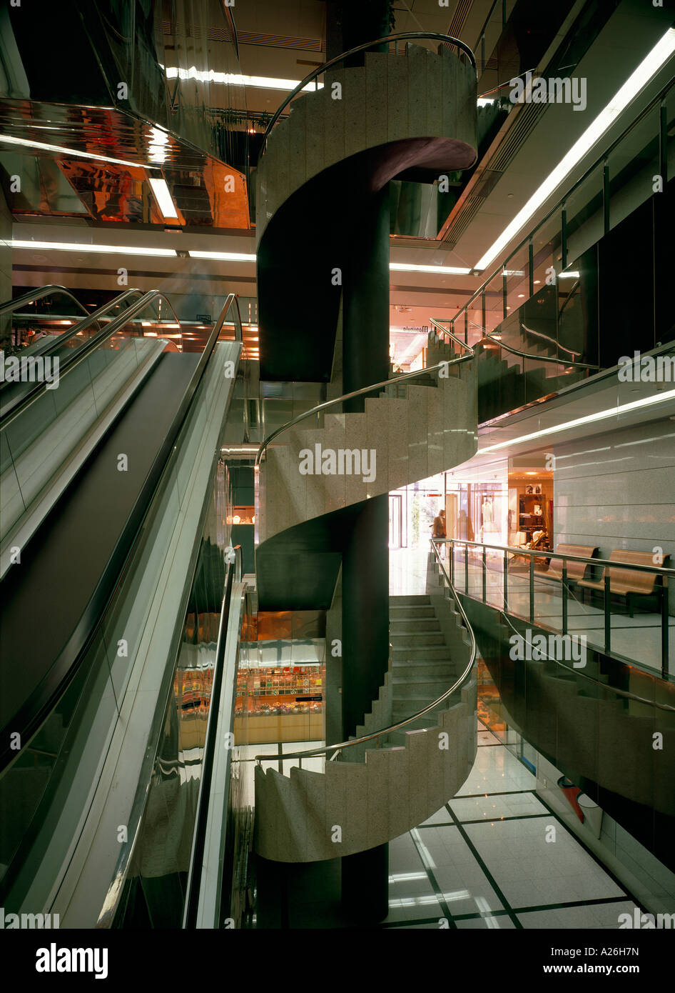 View of escalators and a spiral staircase in a grand shopping mall ...