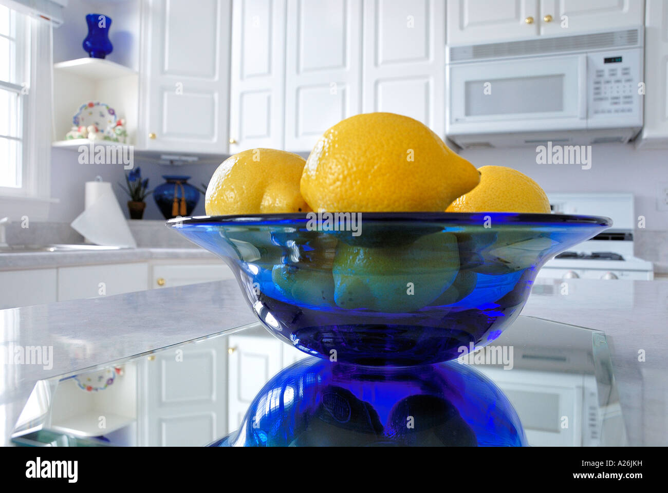 Lemons in a blue bowl in a white kitchen Stock Photo - Alamy