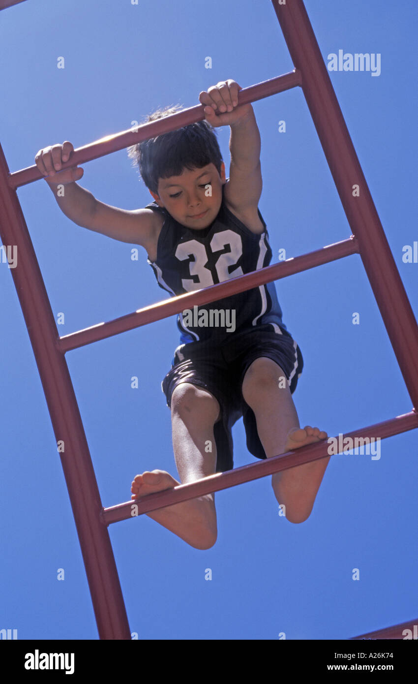 Boy playing on the monkey bars at a park Stock Photo - Alamy