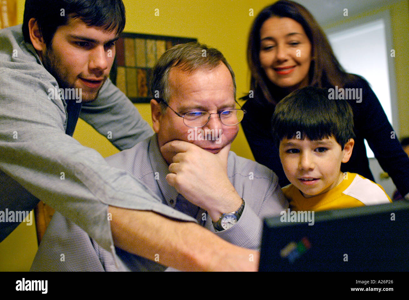 Family around a laptop computer Stock Photo - Alamy