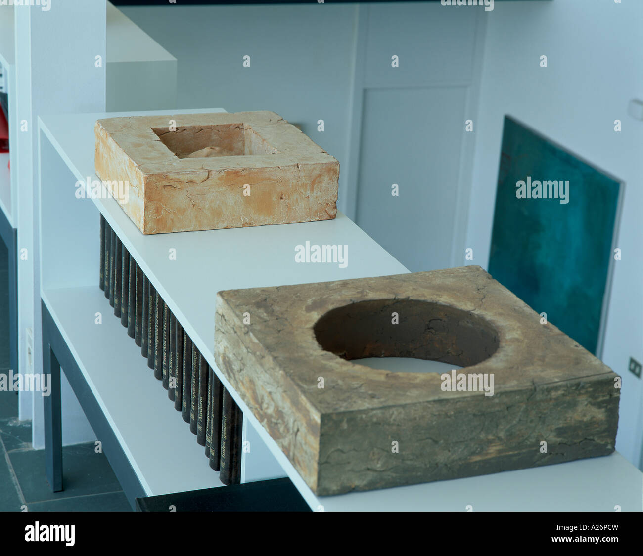Square shaped artifacts above a bookshelf Stock Photo - Alamy