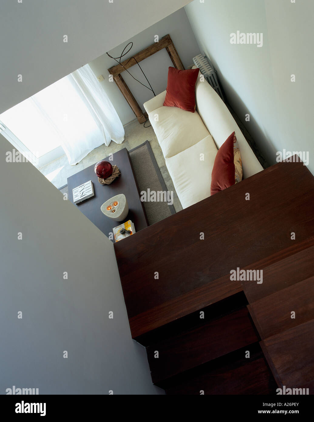 View of a couch through staircase Stock Photo - Alamy