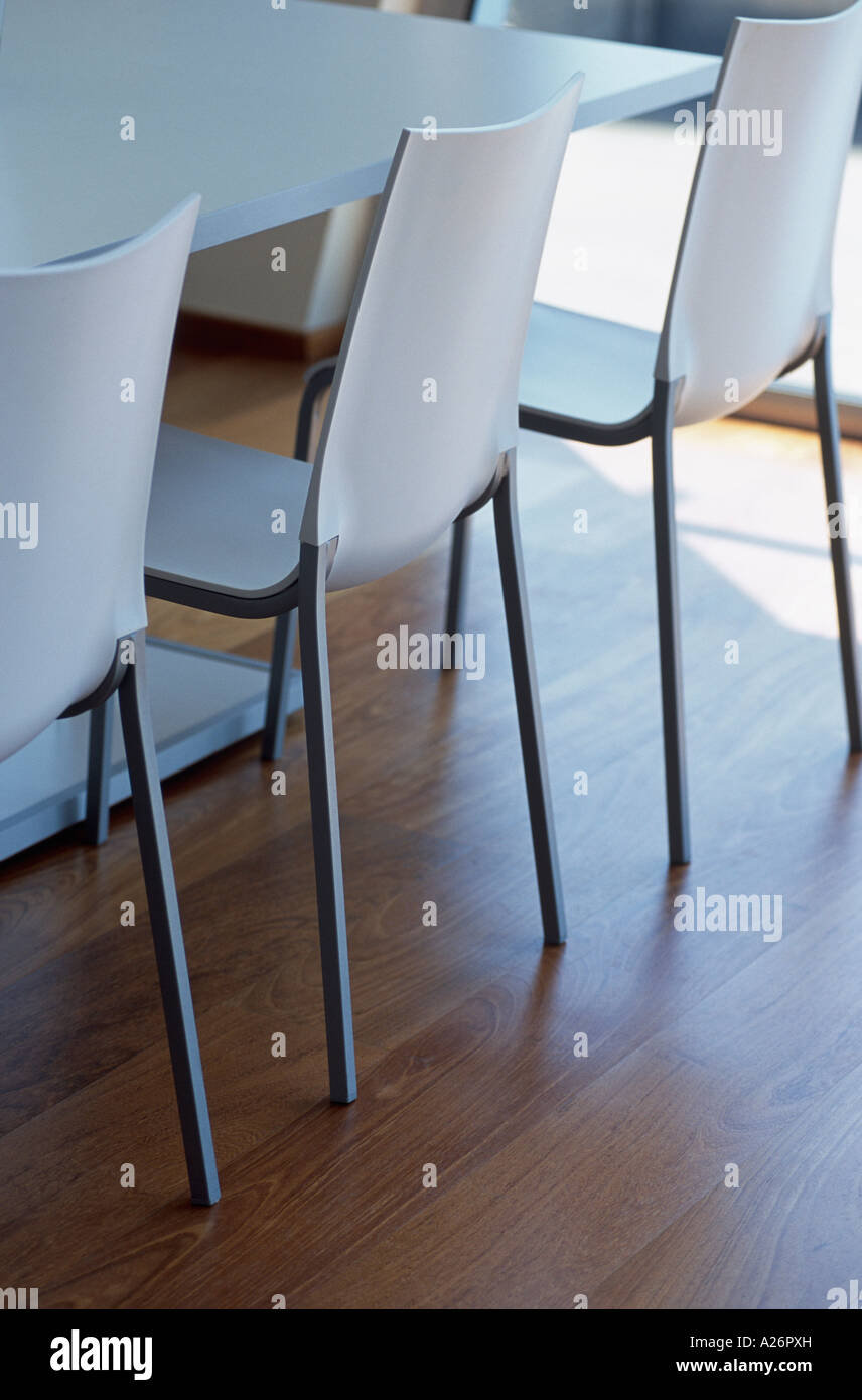 Partial view of table and chairs arranged on hardwood flooring Stock ...