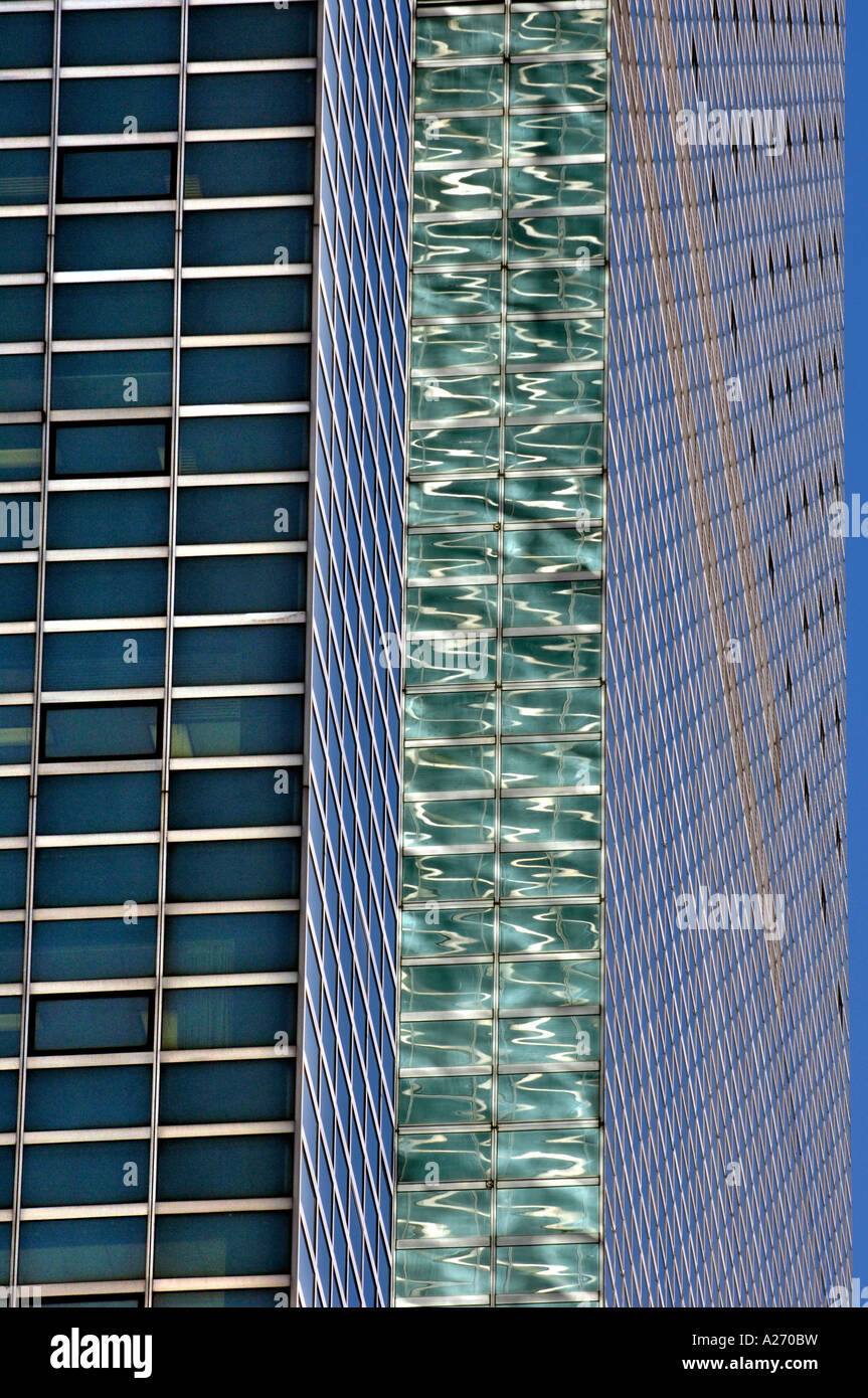 A skyscraper is reflected in the soaring glass tower of another tall ...