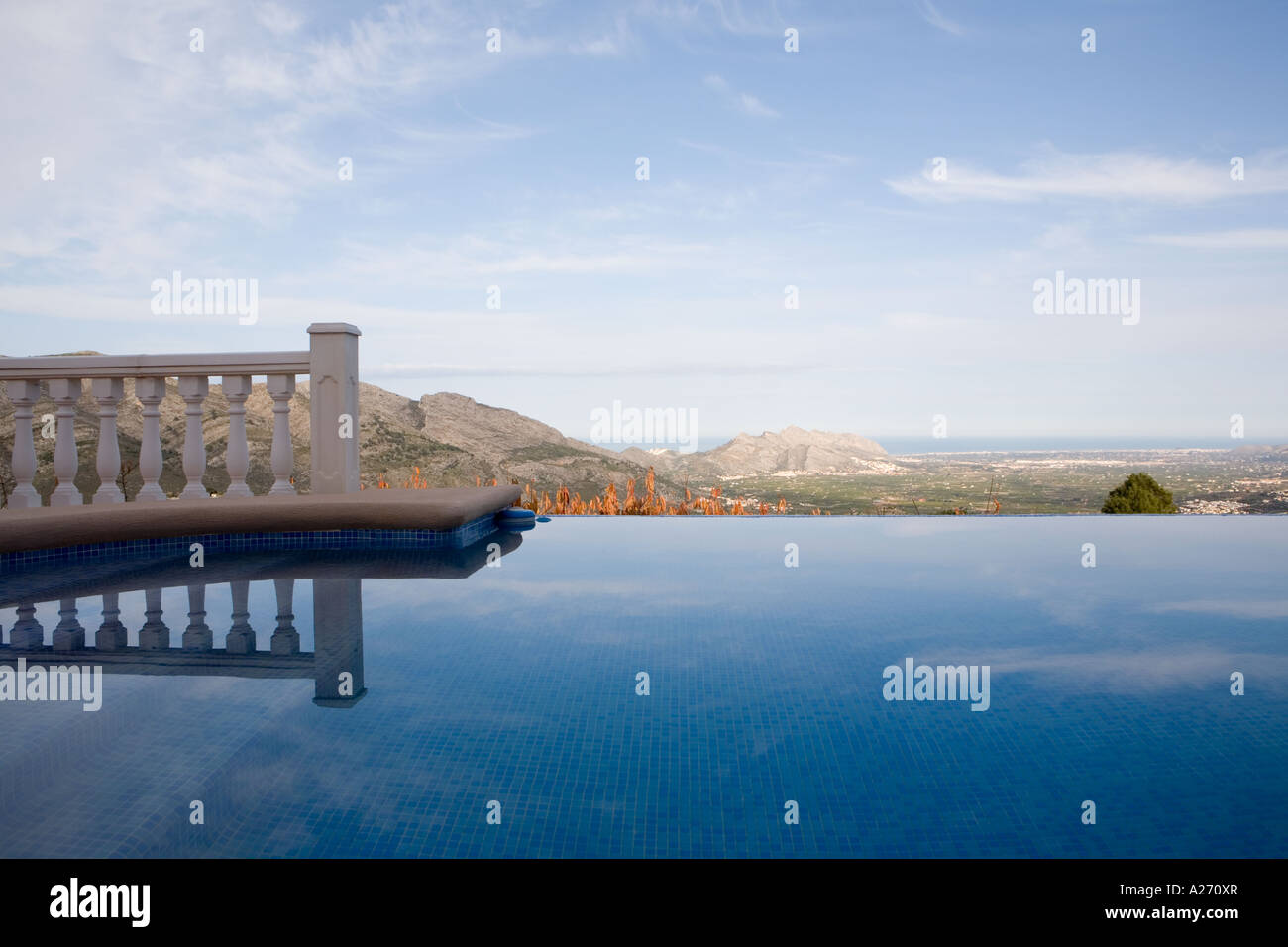 Balustrade reflected in infinity pool with mountains in background ...
