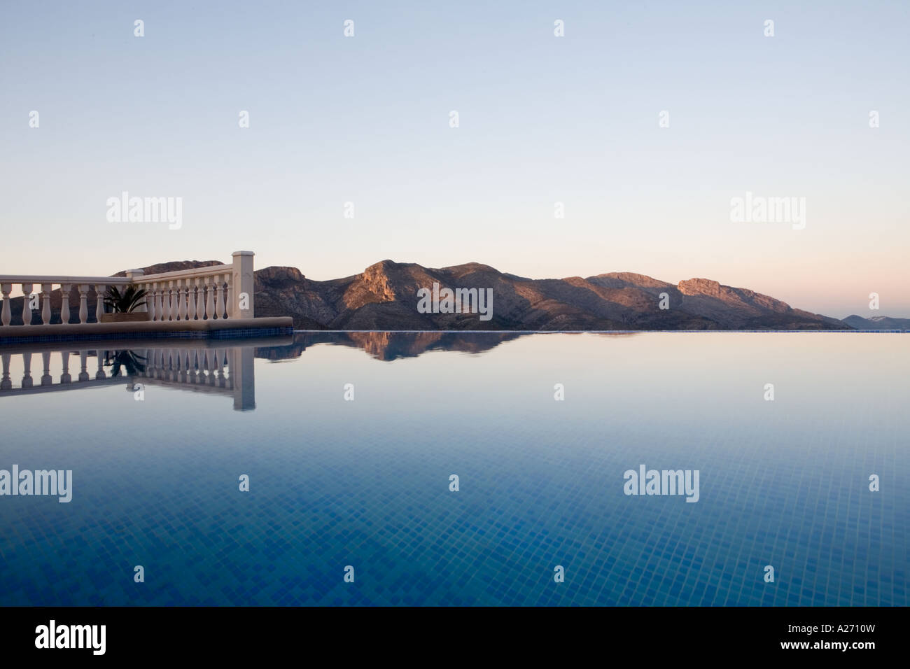 Balustrade and mountains reflected in infinity pool , Spain Stock Photo ...