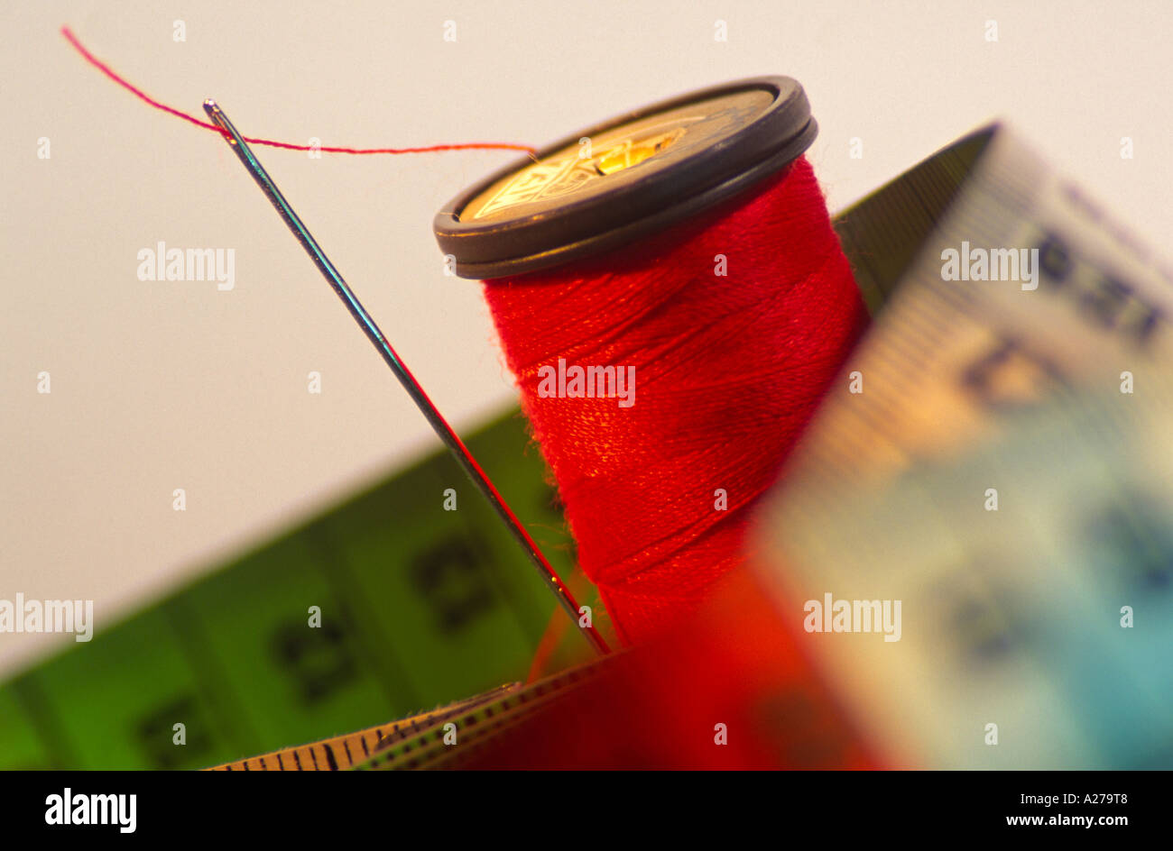 roll with red sewing thread needle and tapeline tape measure and ...
