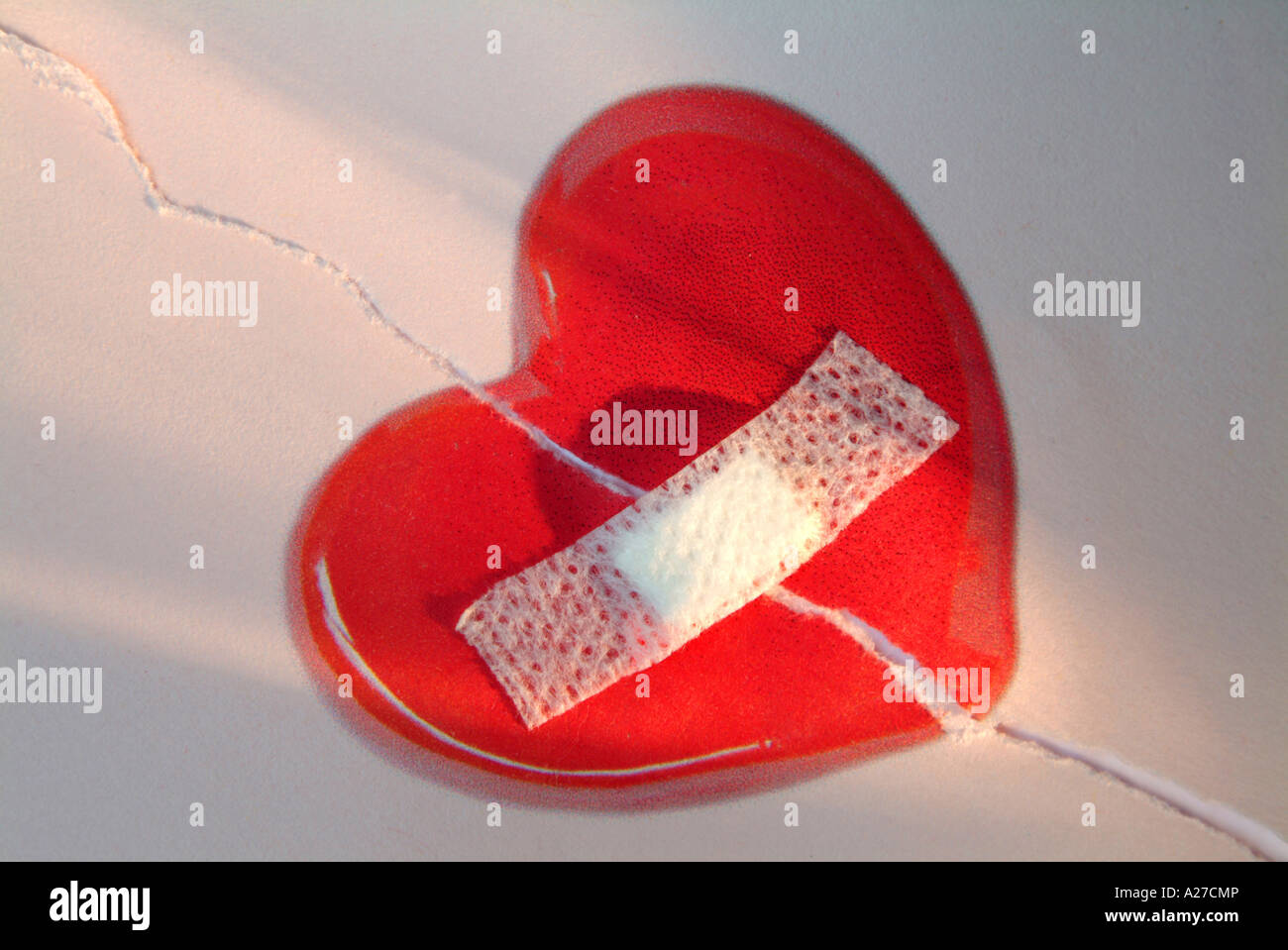 Broken red love heart repaired with band aids Stock Photo - Alamy