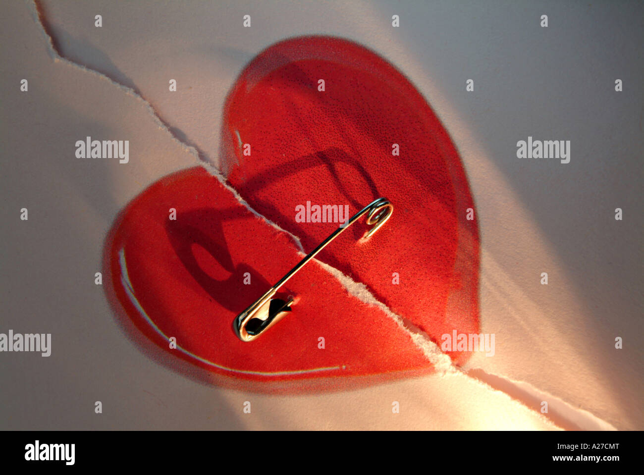Broken red love heart repaired with a safety-pin Stock Photo - Alamy