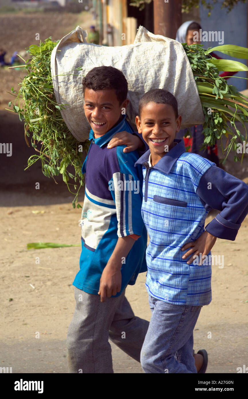 Two Smiling Egyptian Boys Walking and Carrying A Bag Of Grass In Cairo ...