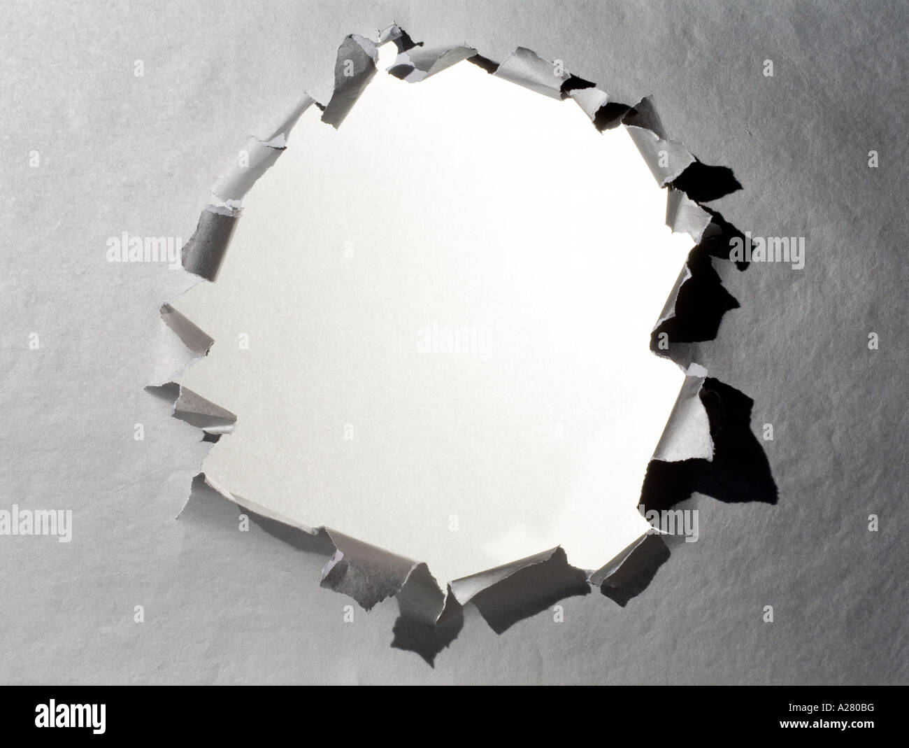 Silver paper breakthrough hole Stock Photo - Alamy