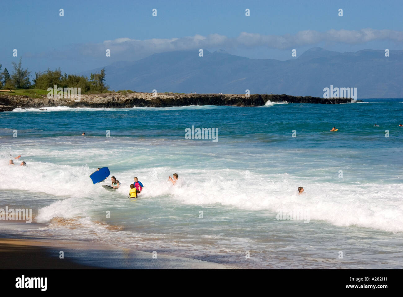 Boogie boarding on waves in the pacific ocean off the island of Maui ...