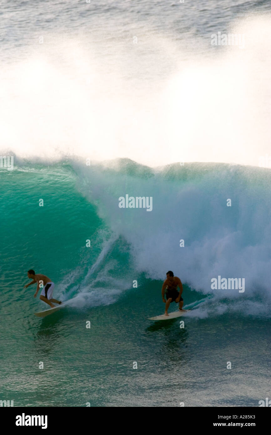 Surfing on waves in the pacific ocean off the island of Maui, Hawaii ...