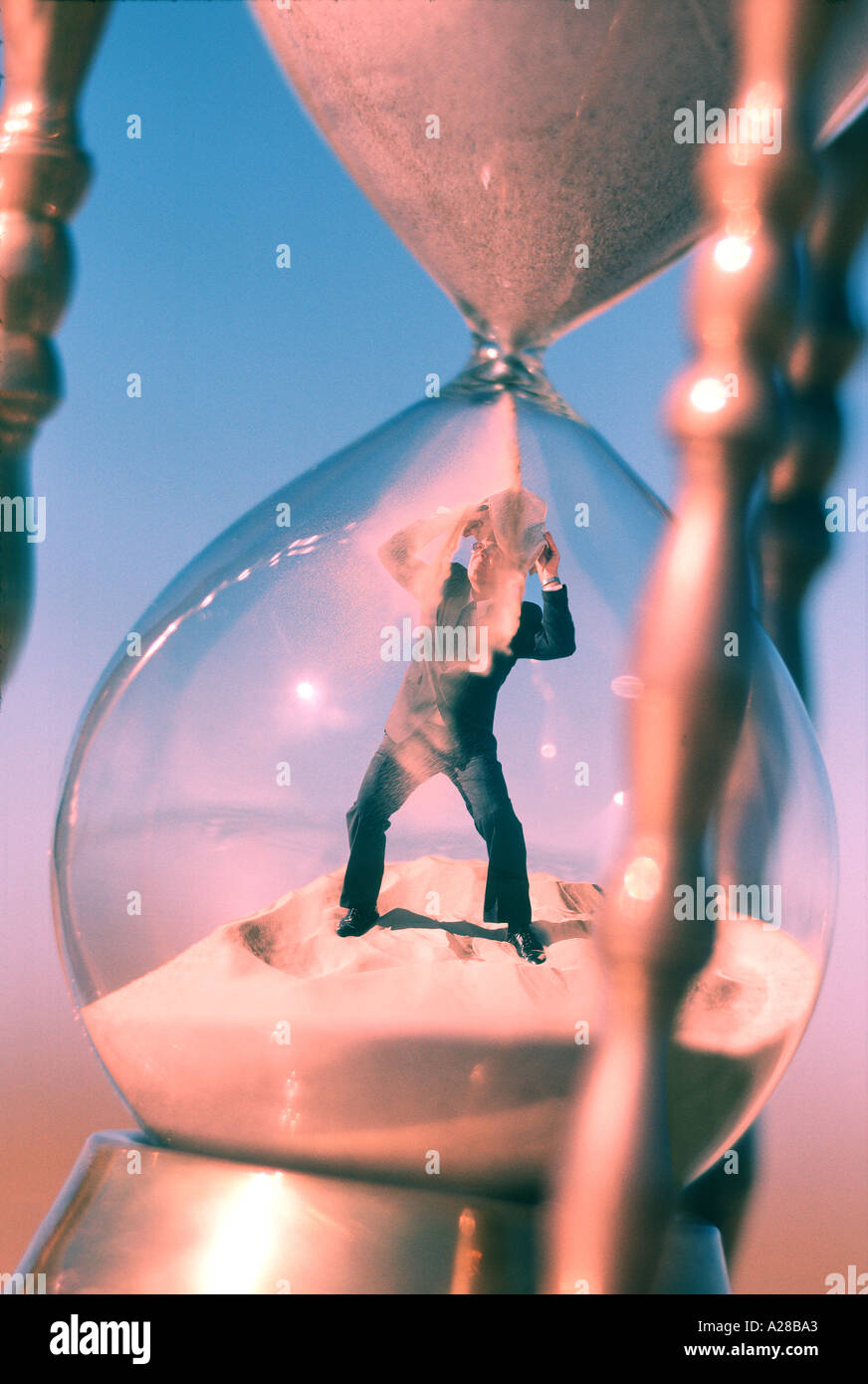 Businessman trapped in hourglass with sand falling on him Stock Photo ...