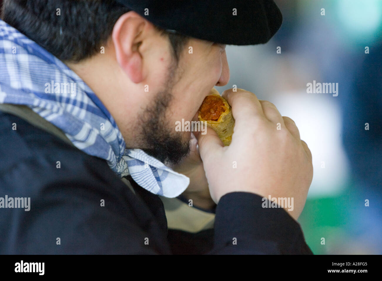 Man in traditional Basque dress and wearing a beret eating talo con ...