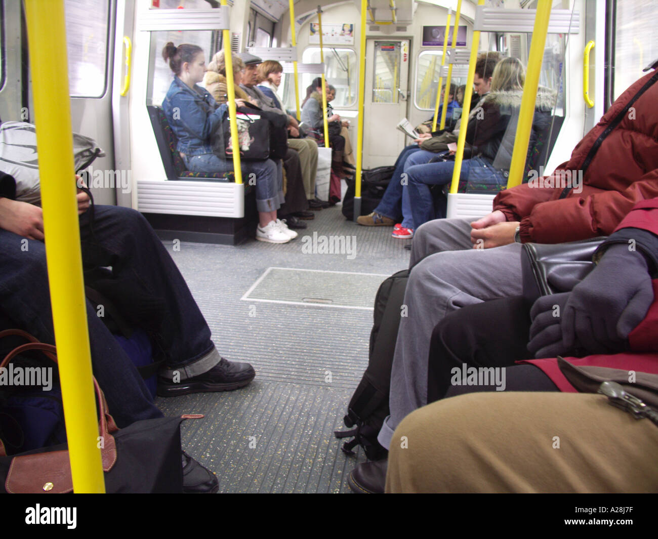 Legs and feet of passengers on London undergound train Stock Photo - Alamy