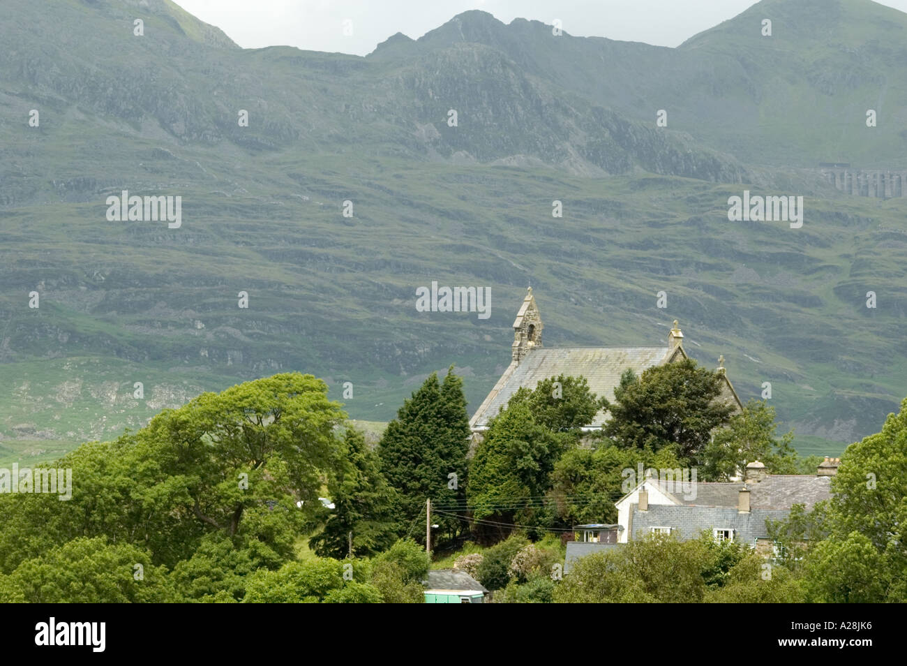 Distant view of church and trees with mountains in background Stock ...