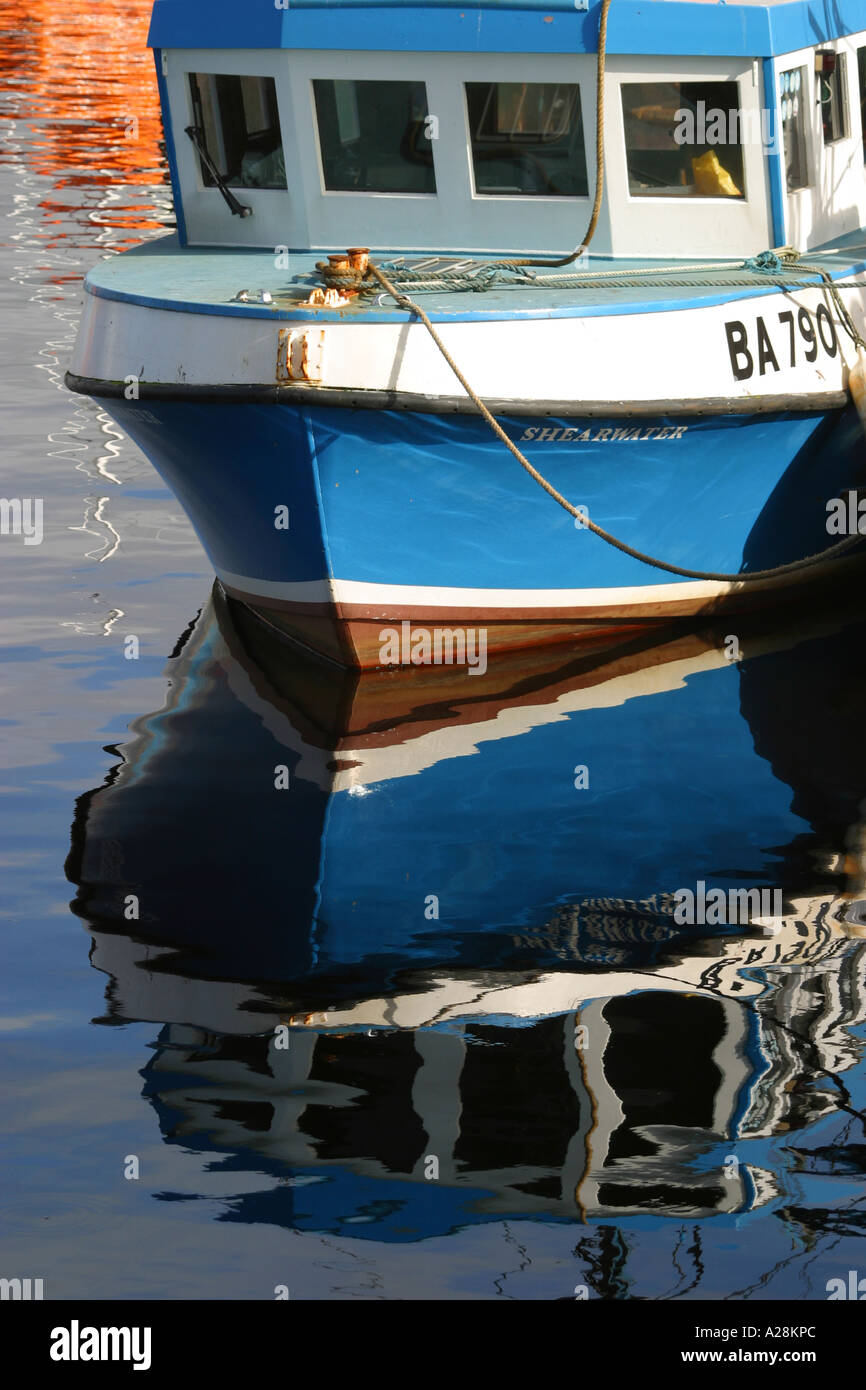 Fishing boat and reflection on harbour water Stock Photo - Alamy