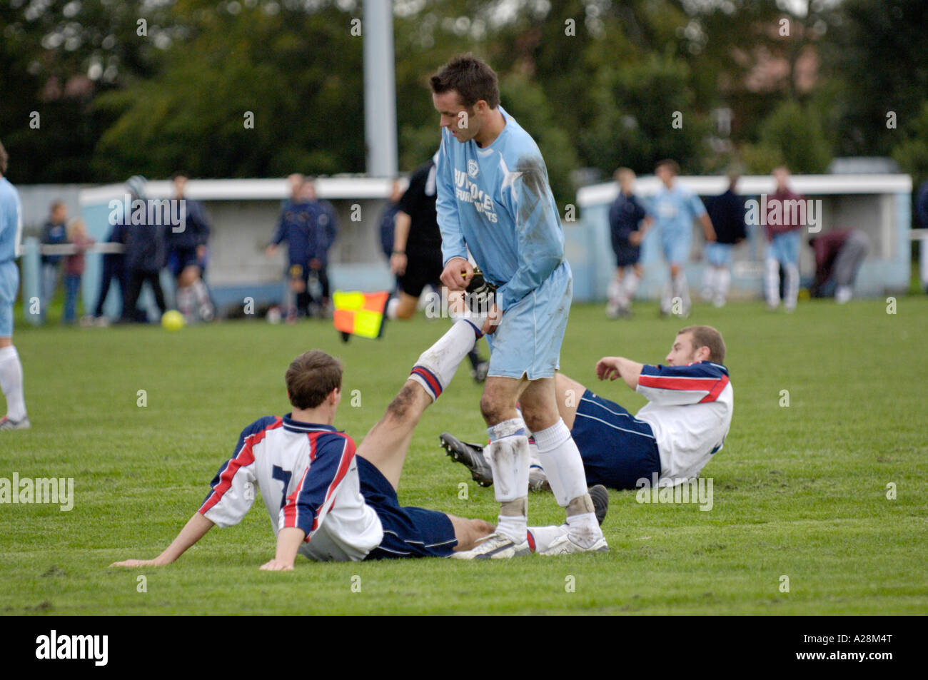 Footballer helps an opponent with cramp Stock Photo - Alamy