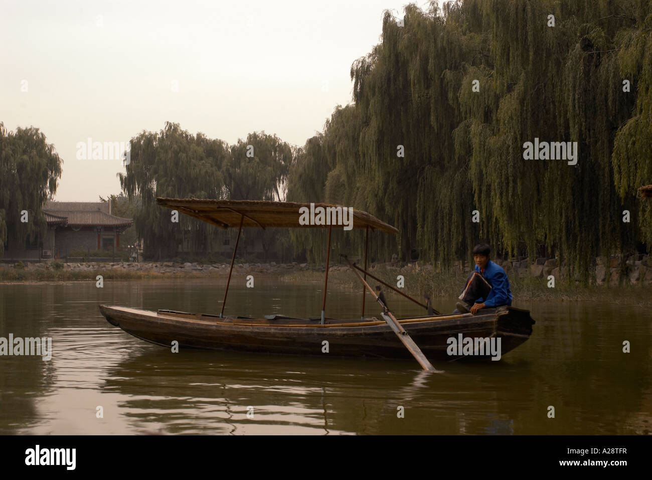 Chinese boy in traditional boat at the Old Summer Palace in Beijing ...