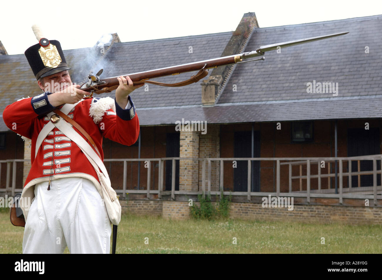 Man in historic English army soldier uniform firing a Rifle with a ...