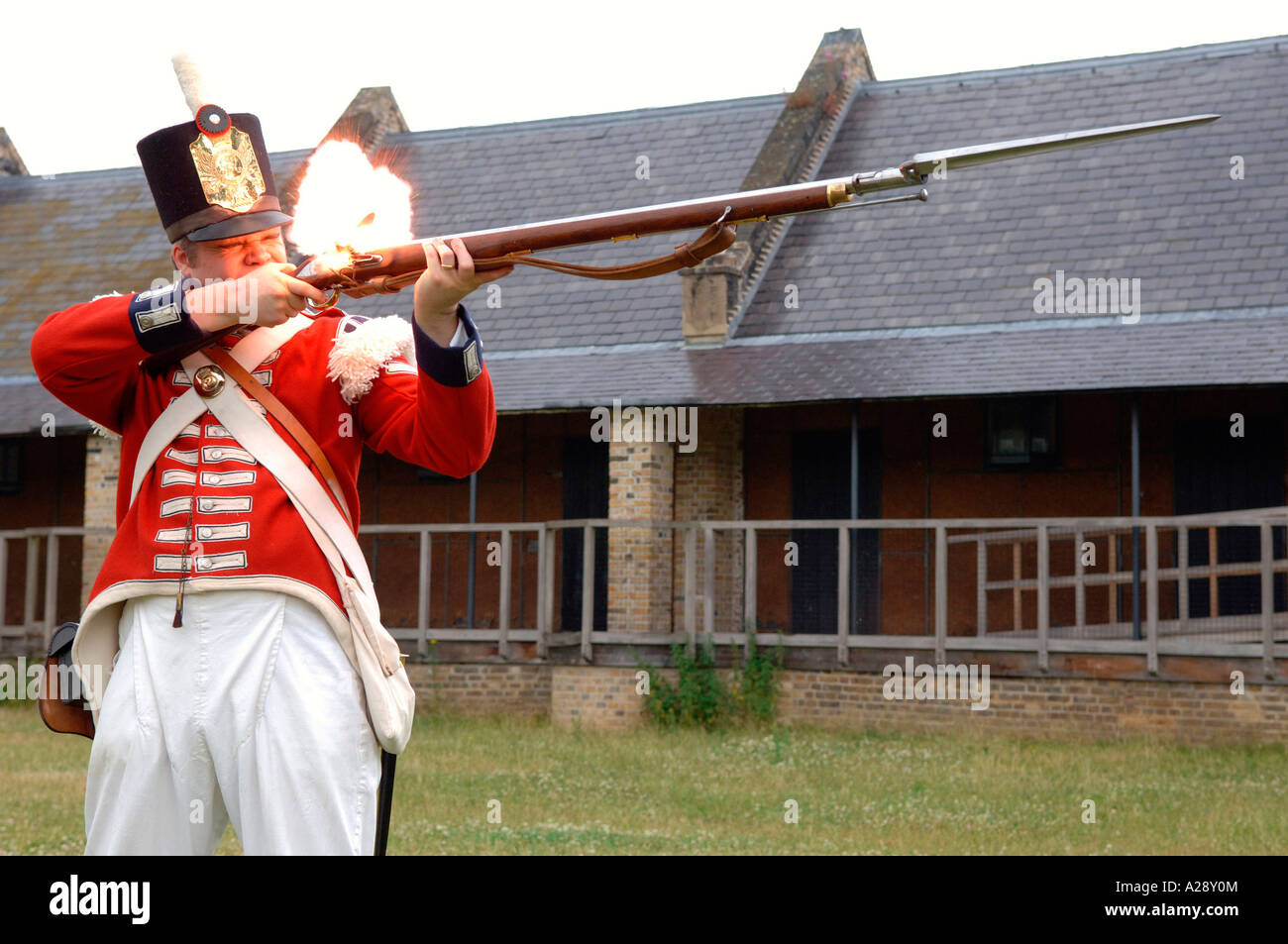 Man in historic English army soldier uniform firing a Rifle with a ...