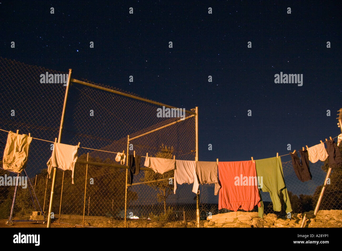 Clothes hanging out to dry on a line under the stars in a night sky ...