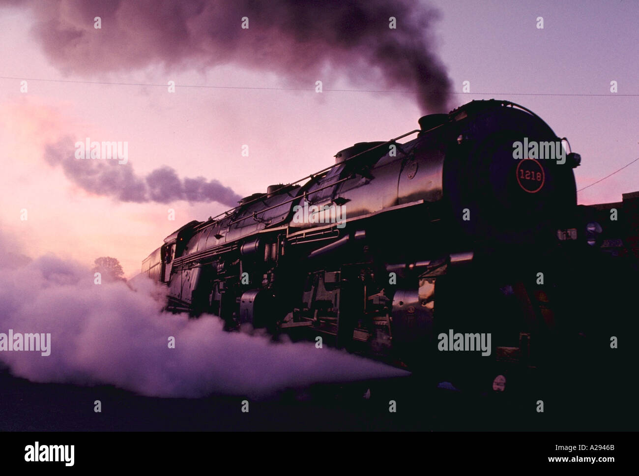 Old time steam locomotive billowing steam and smoke moving down the ...