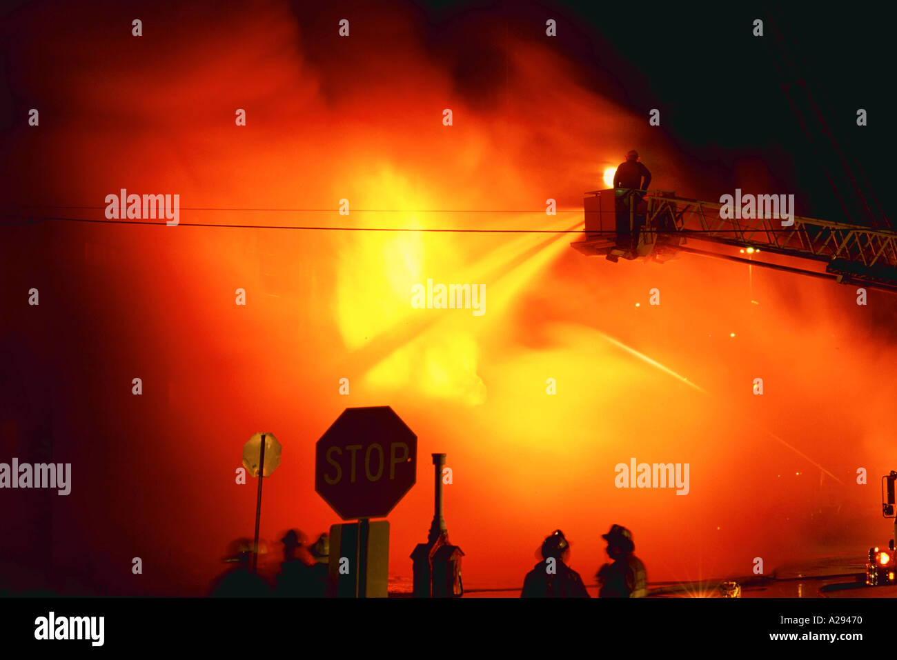 Fire Wall of flames with firefighters visible including a boom hose ...