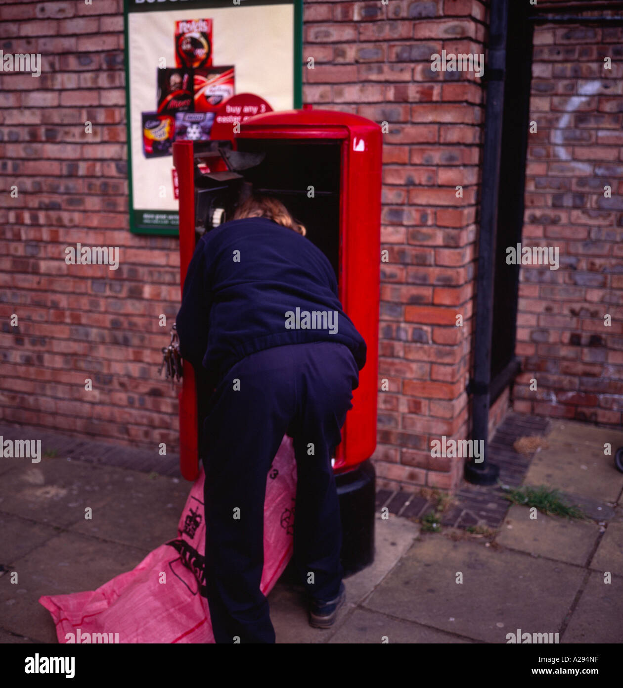 Postman emptying post box Stock Photo - Alamy