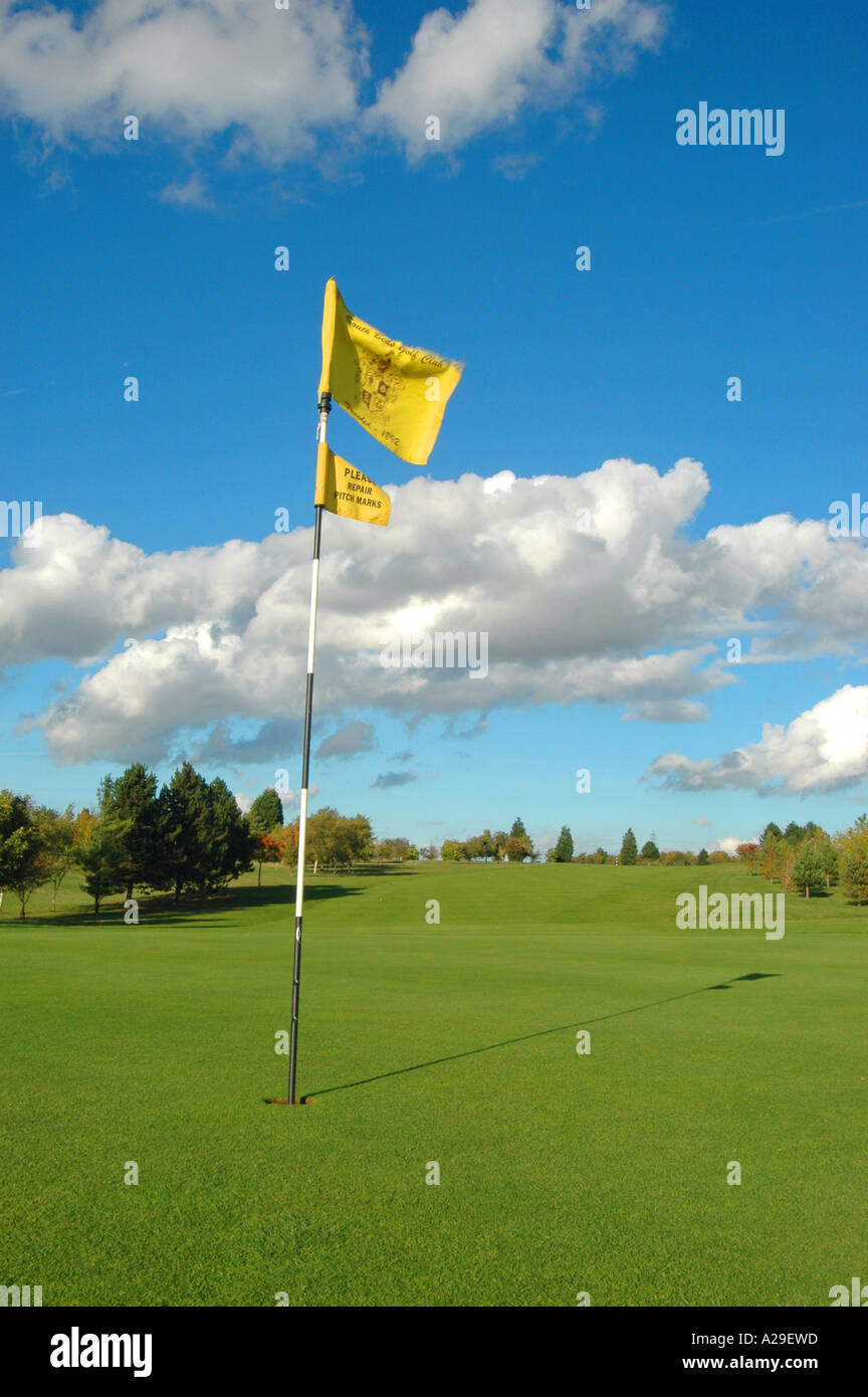 Golf course. Shot low from the back of the green. The yellow flag in ...