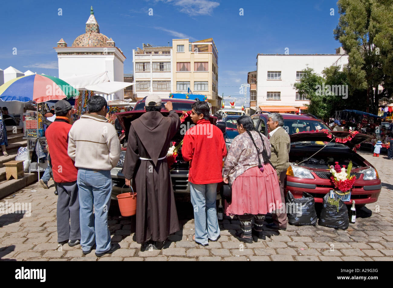 A priest in the process of blessing a vehicle at the entrance to the ...