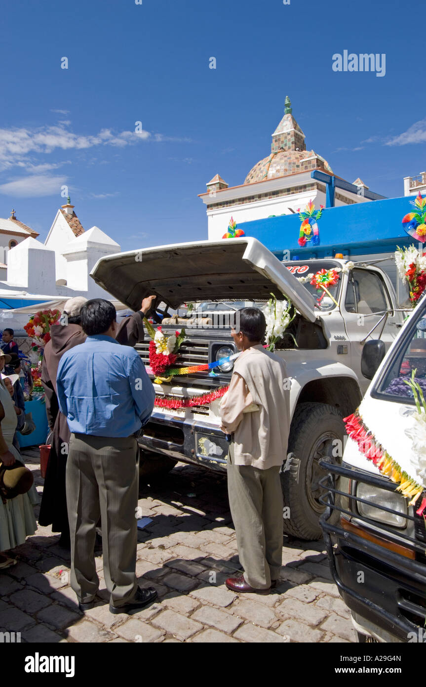 A priest in the process of blessing a vehicle at the entrance to the ...