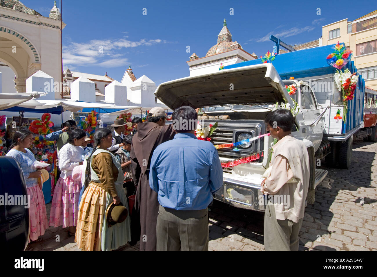 A priest in the process of blessing a vehicle at the entrance to the ...
