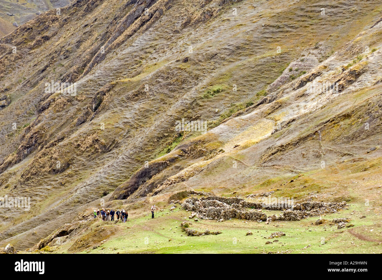 A group of tourists and guides trekking through the rugged scenery of ...