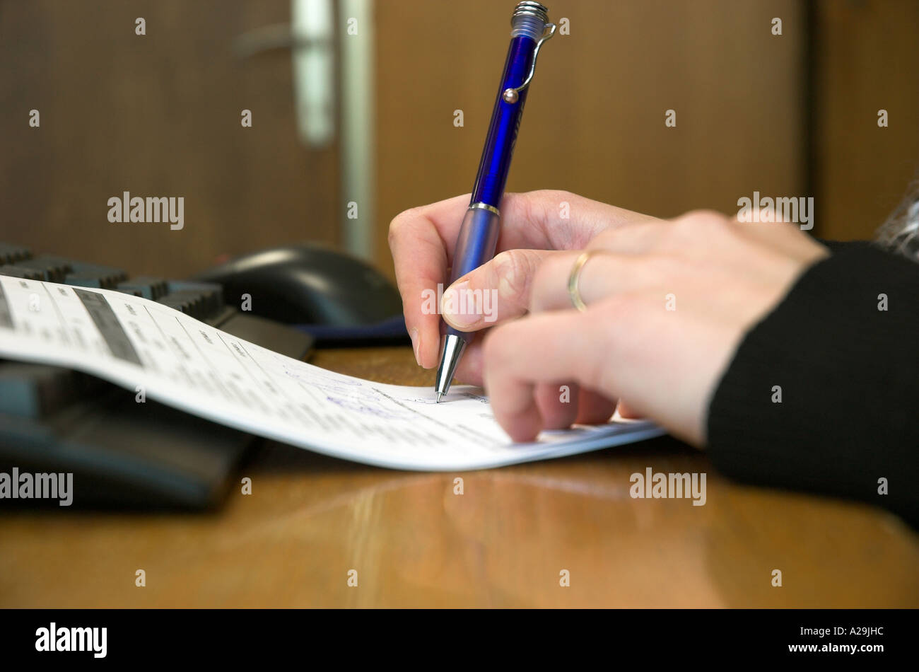 Female hand signing a document Stock Photo - Alamy
