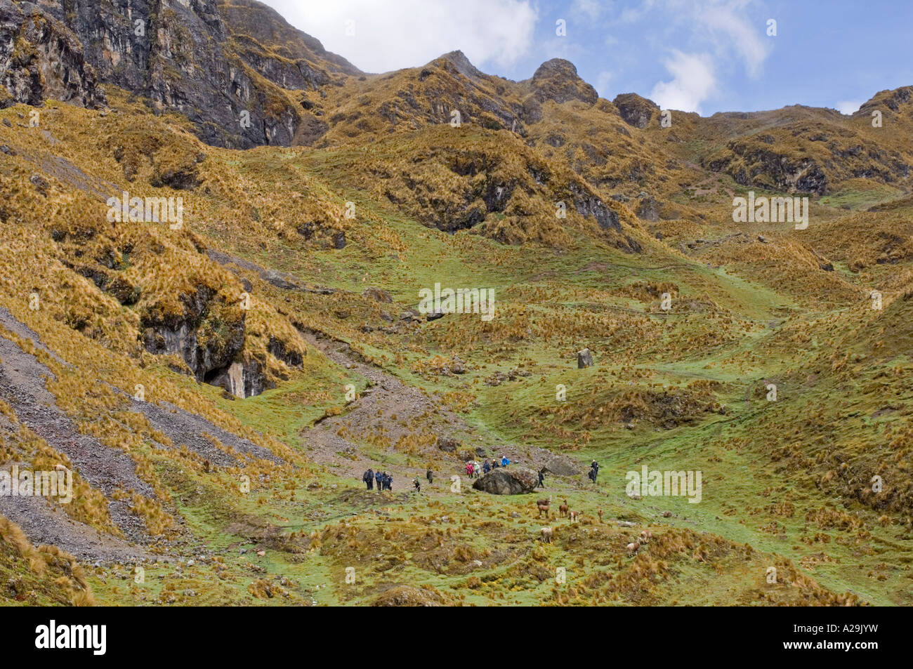 A group of tourists and guides trekking through the rugged scenery of ...