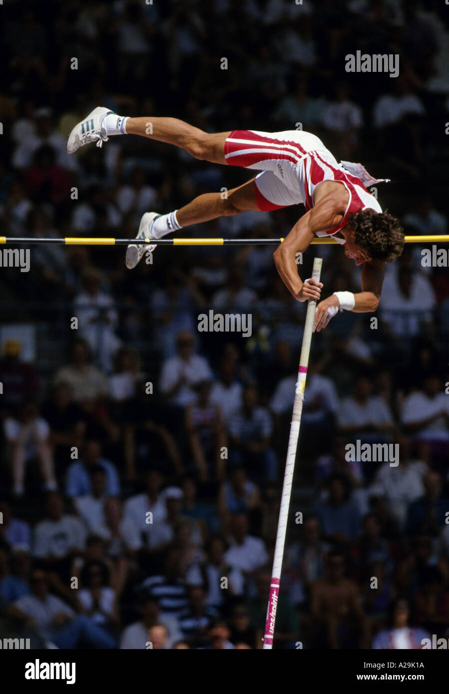 A vaulter stretches to clear the bar in a Pole Vault competition Stock ...