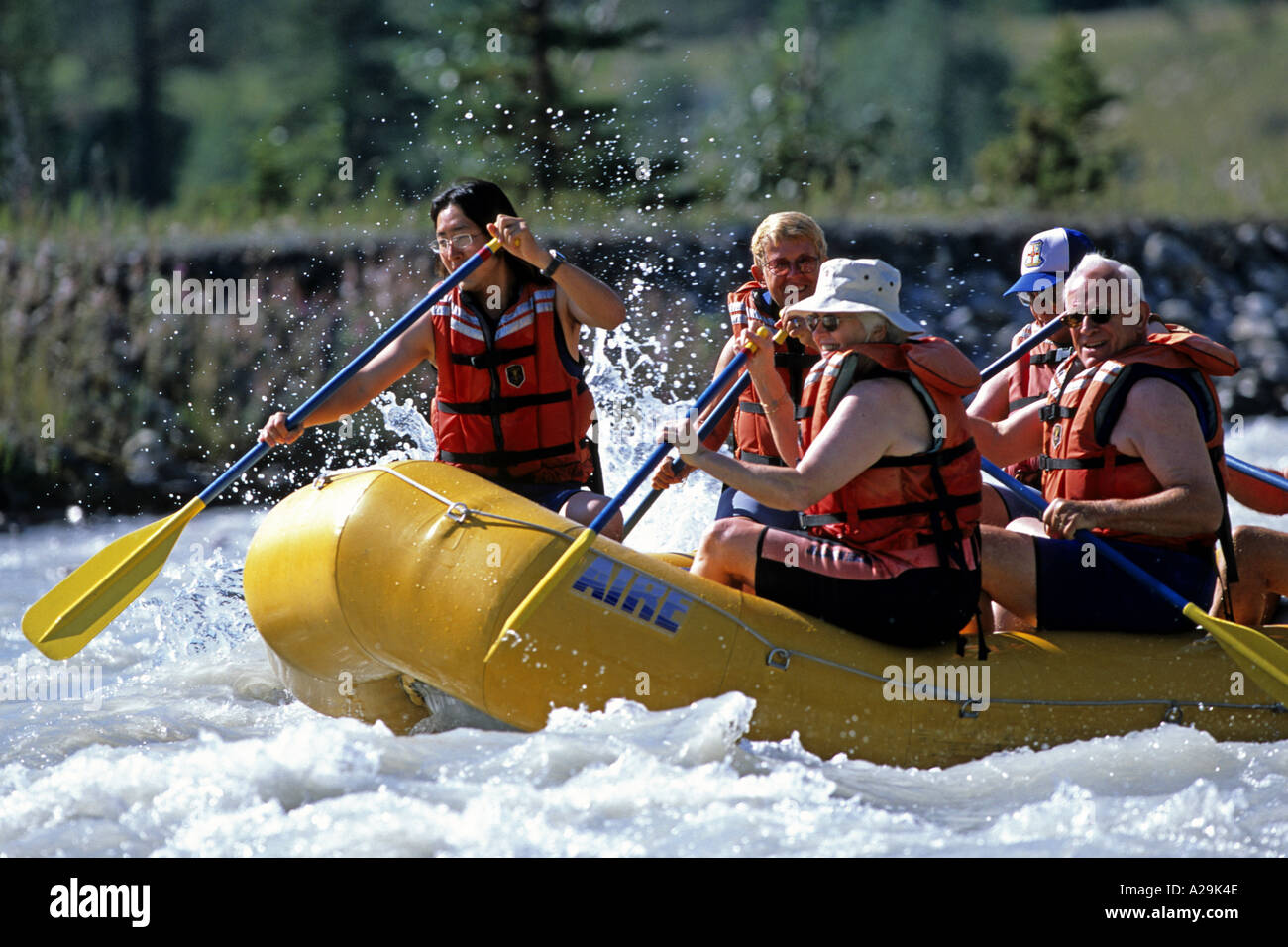 A party of middle aged holiday makers rafting down the Kootenay River ...