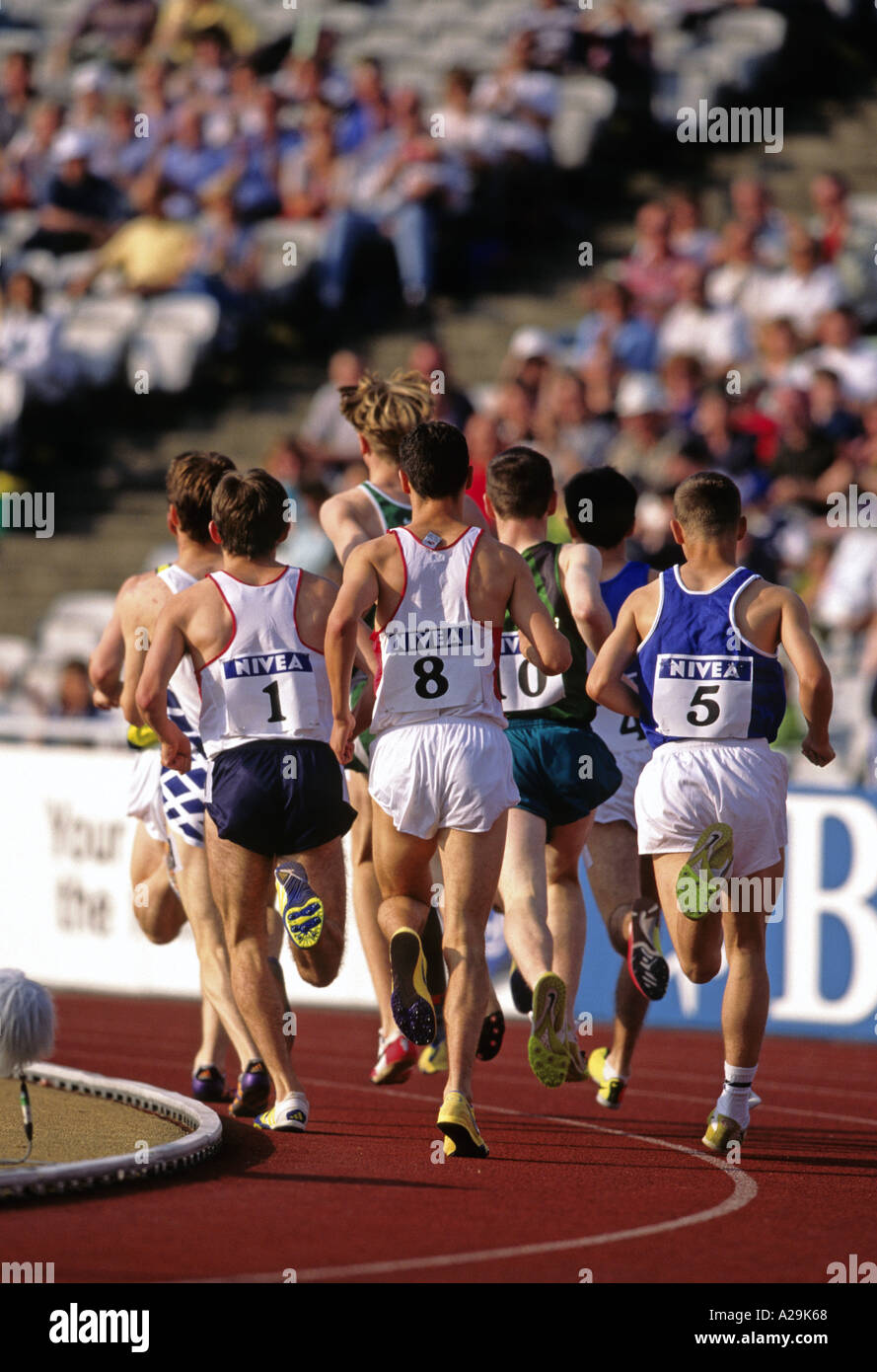 View from behind of a group of male runners taking the bend during a ...