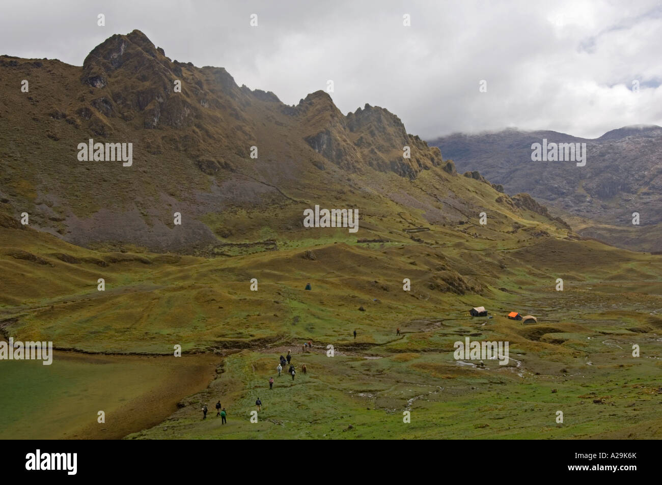 A group of tourists and guides trekking through the rugged scenery of ...