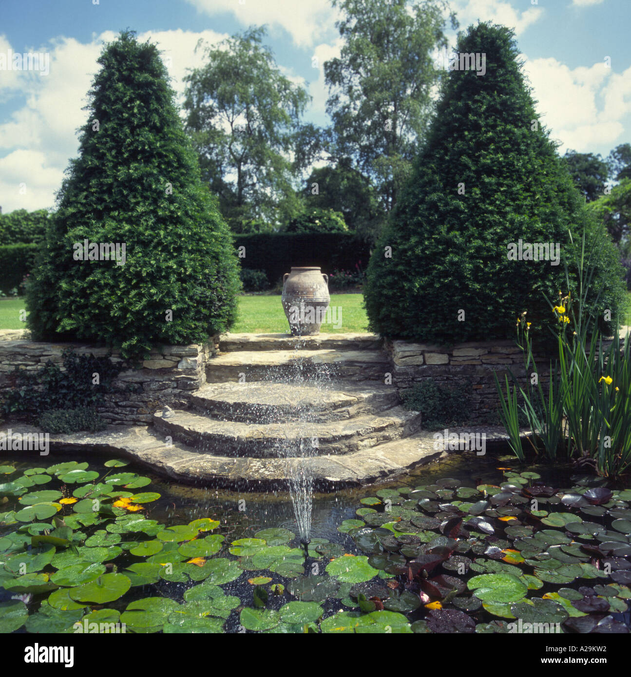 Formal stone built garden pond and fountain water feature Stock Photo ...