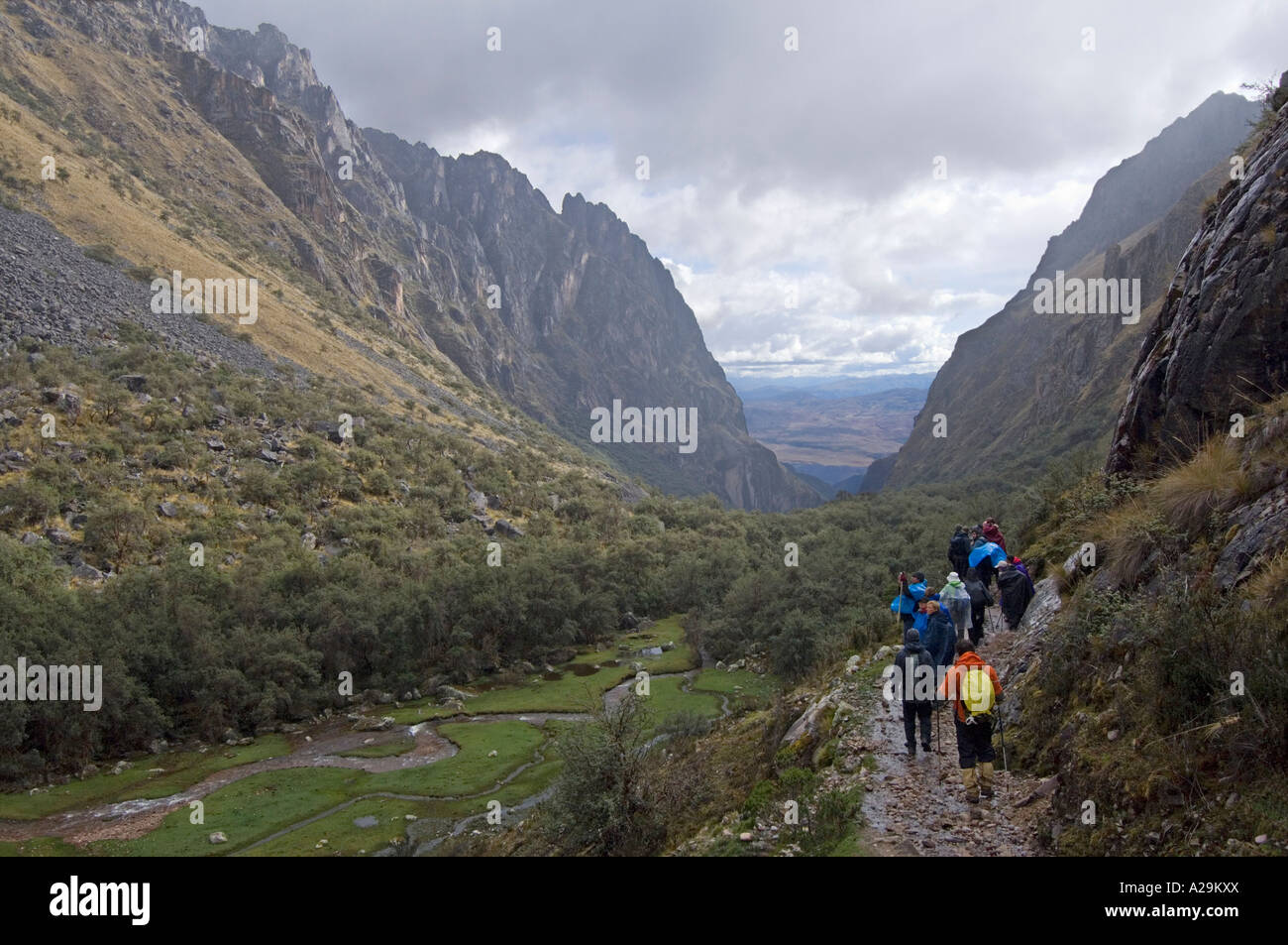 A group of tourists and guides trekking through the rugged scenery of ...
